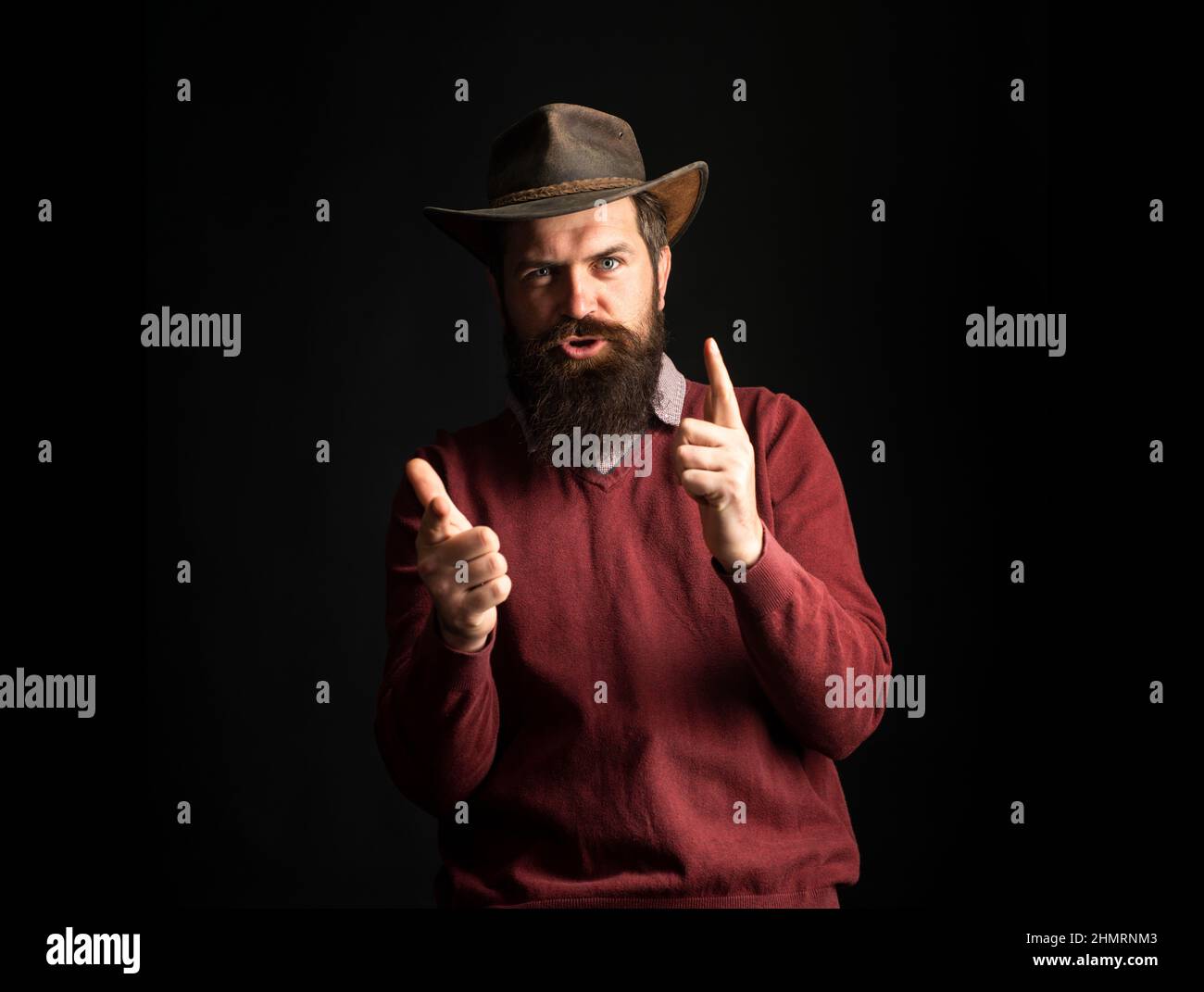 Bearded cowboy man in cowboy hat. Wild west guns, finger revolver ...