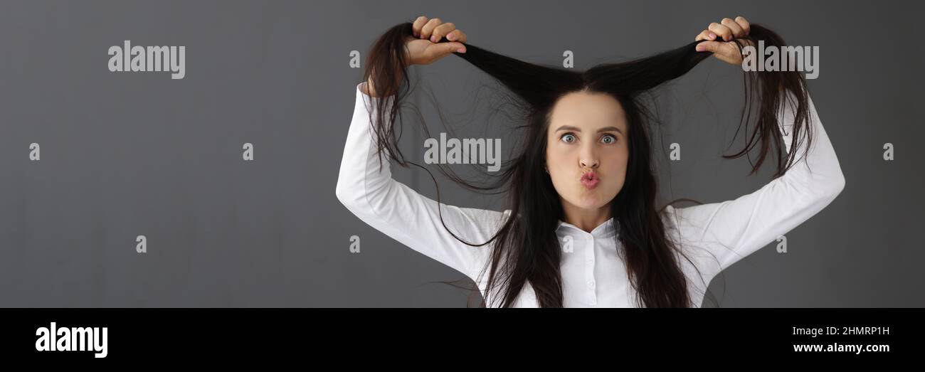Surprised woman lifting her hair up portrait Stock Photo - Alamy
