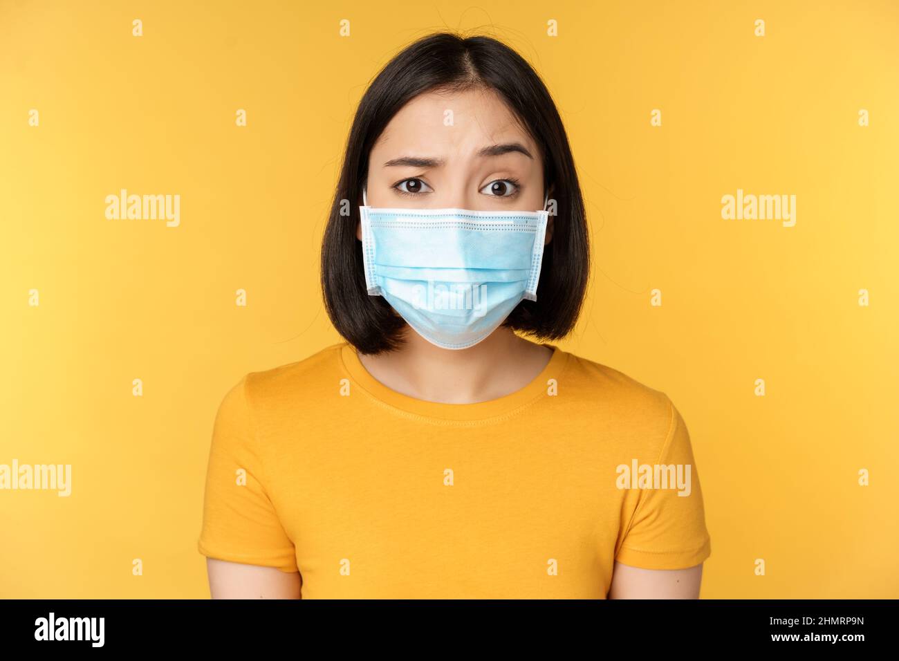 Portrait of skeptical and confused asian woman in medical face mask ...