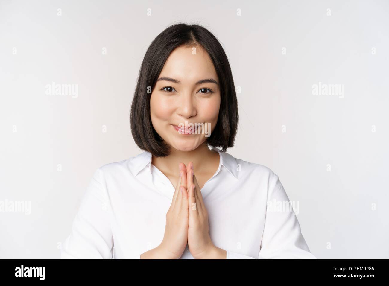 Close up portrait of young japanese woman showing namaste, thank you ...
