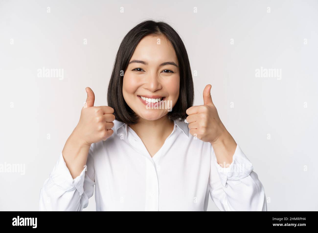 Cheerful asian woman face, showing thumbs up and smiling, pleased by ...