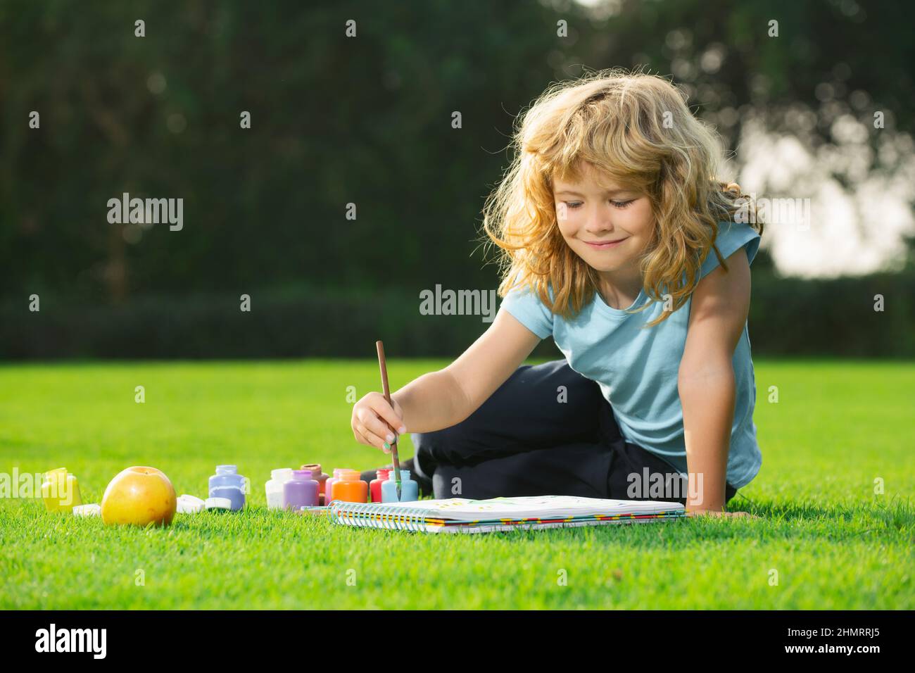 Child painting drawing art. Schooler kids drawing in summer park ...