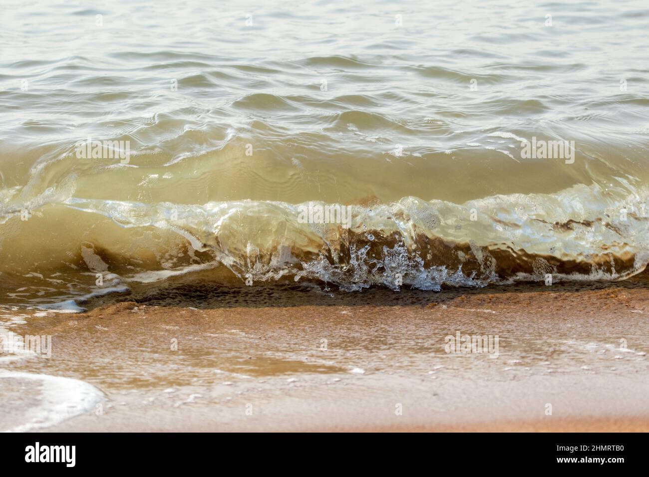 small wave splashing on the beach sand Stock Photo - Alamy