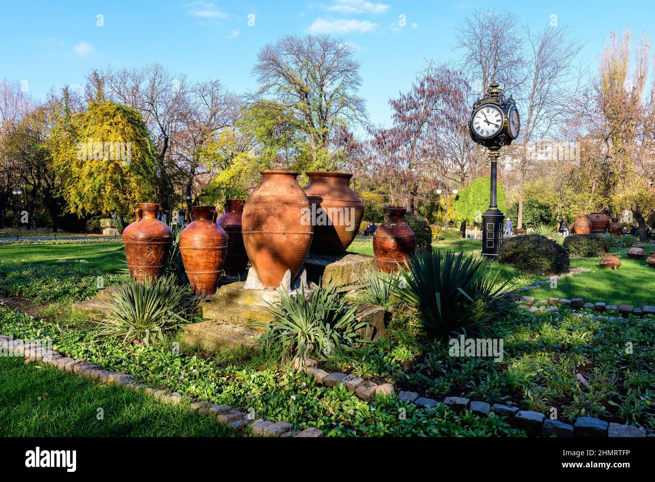 Landscape with the main entrance with vivid green and yellow plants ...