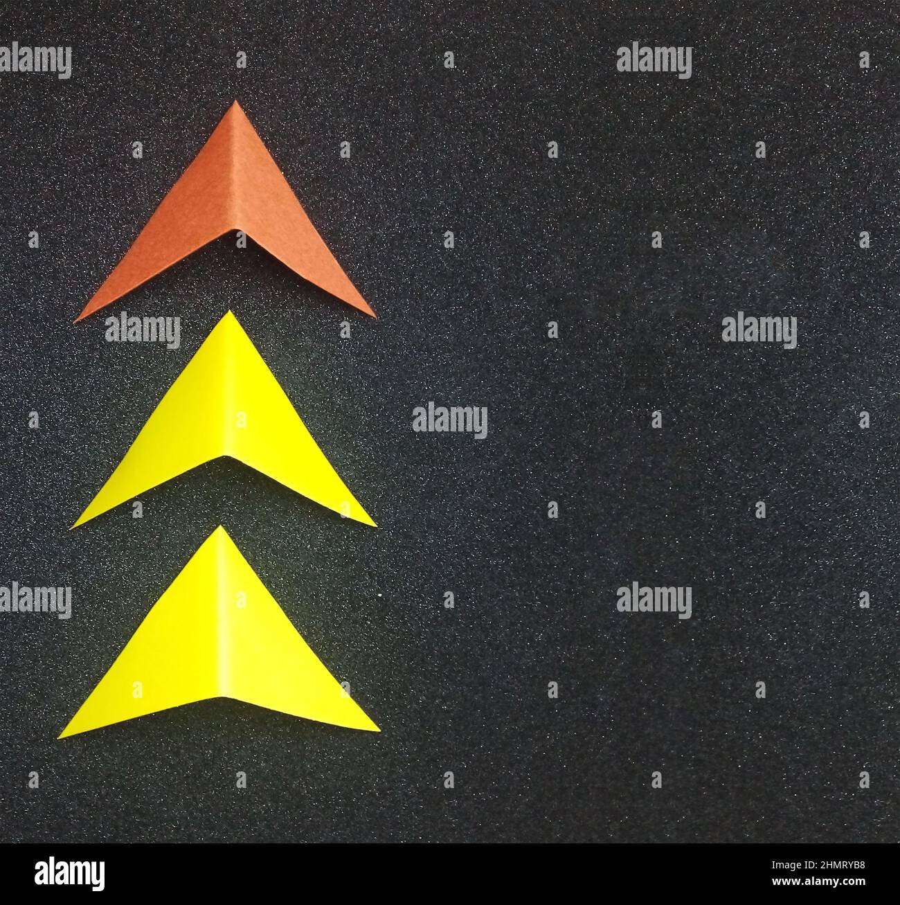 Closeup of paper arrows on a black background Stock Photo - Alamy