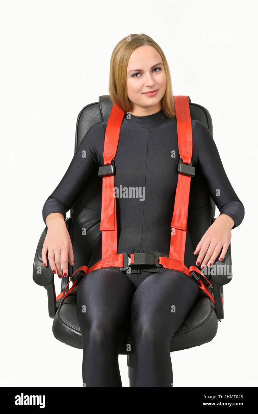 Woman wearing a catsuit buckled up in an office chair Stock Photo - Alamy