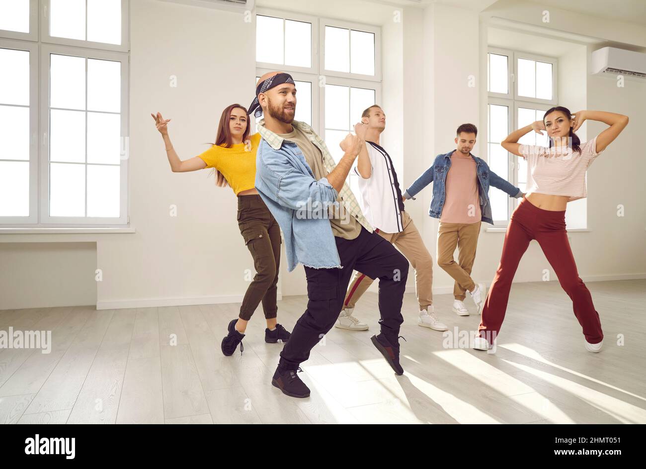 Group of happy young men and women having a dancing class in a modern ...