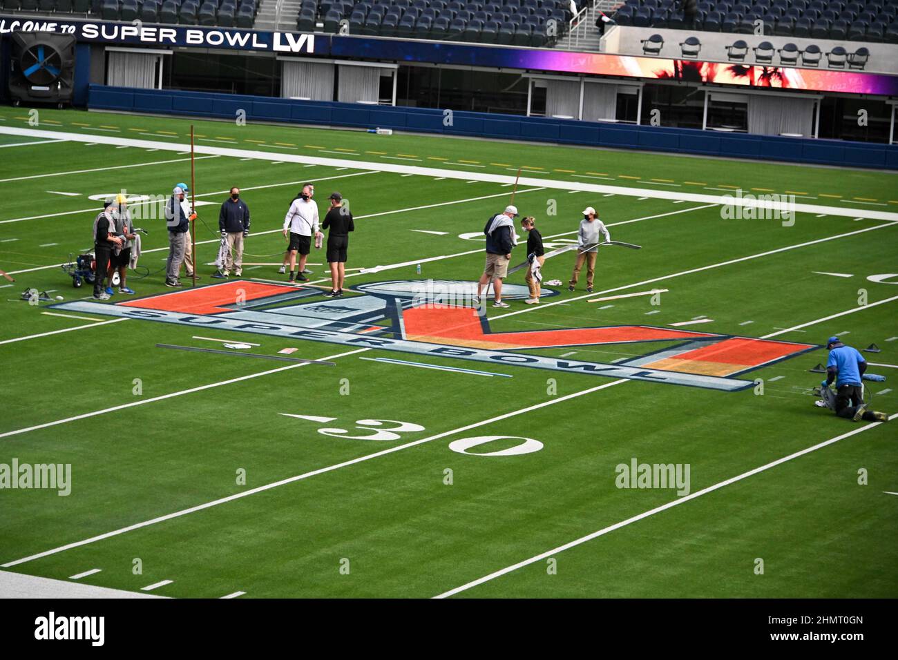 Crews paint the NFL and Super Bowl LVI logos on the field at SoFi ...