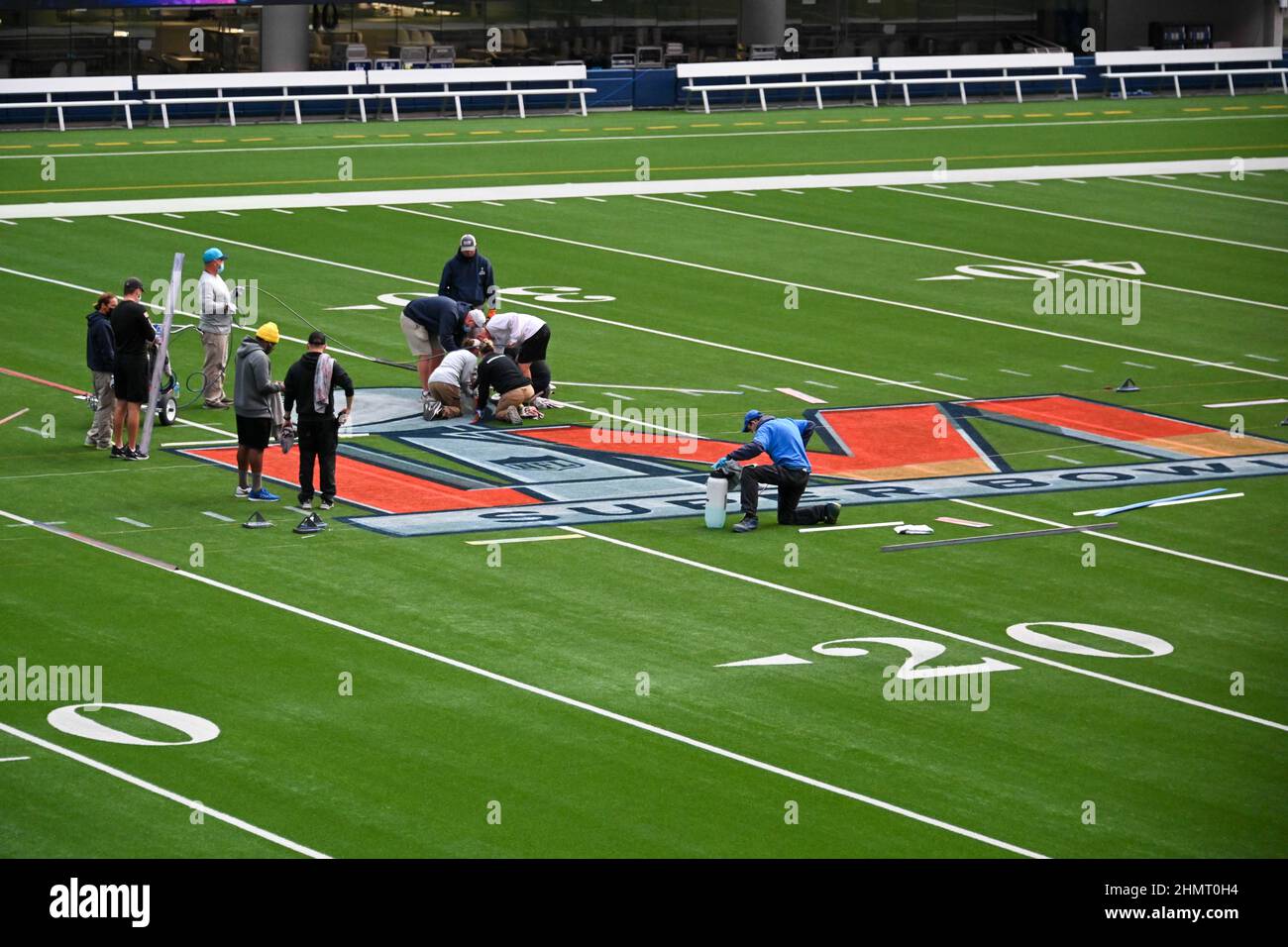 Crews paint the NFL and Super Bowl LVI logos on the field at SoFi ...