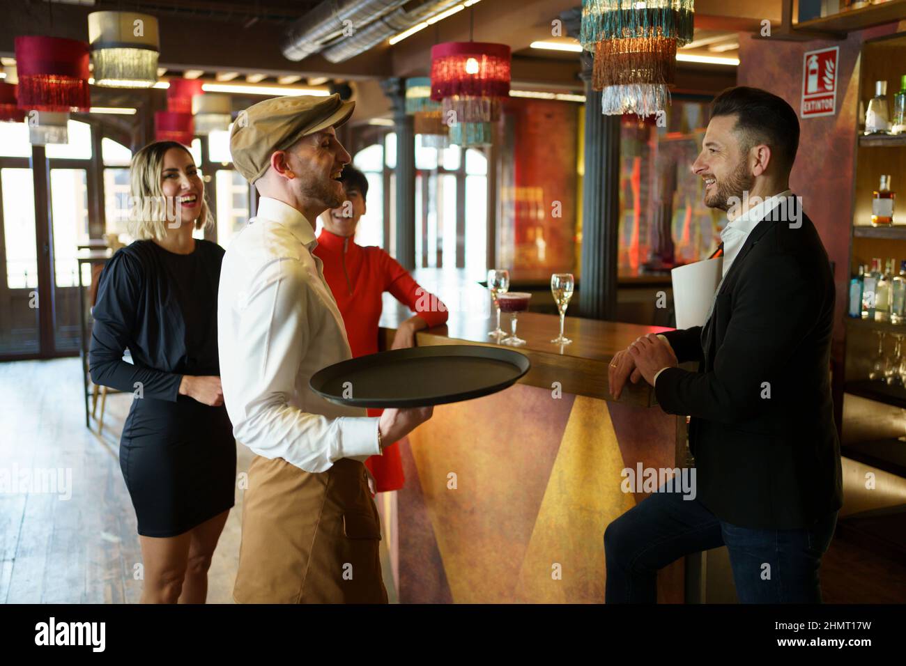Barman serving cocktail on counter for clients Stock Photo - Alamy