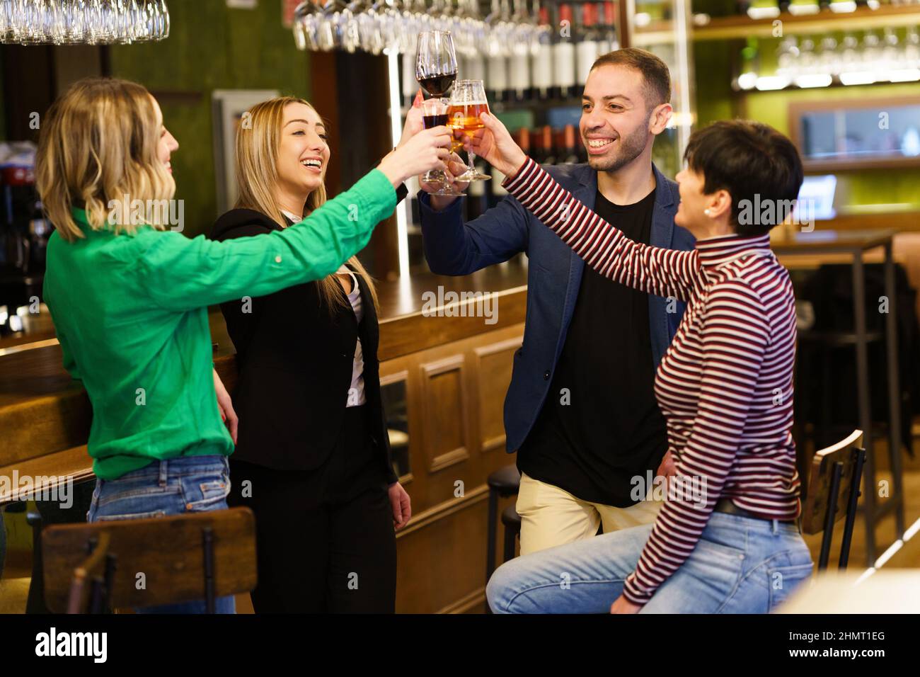 Happy young people proposing toast in a pub Stock Photo - Alamy