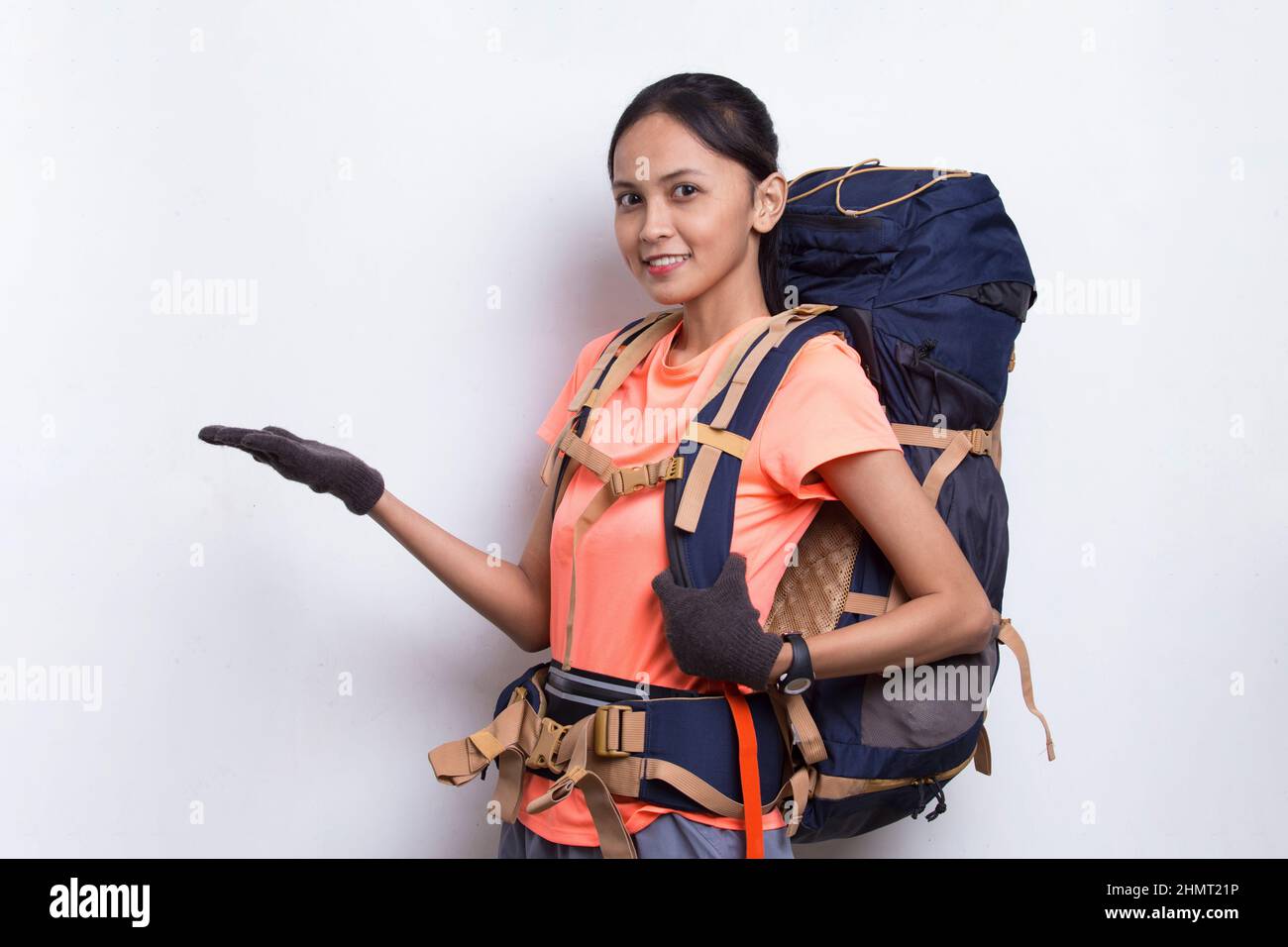 Young asian hiker woman with backpack pointing finger on empty space on ...