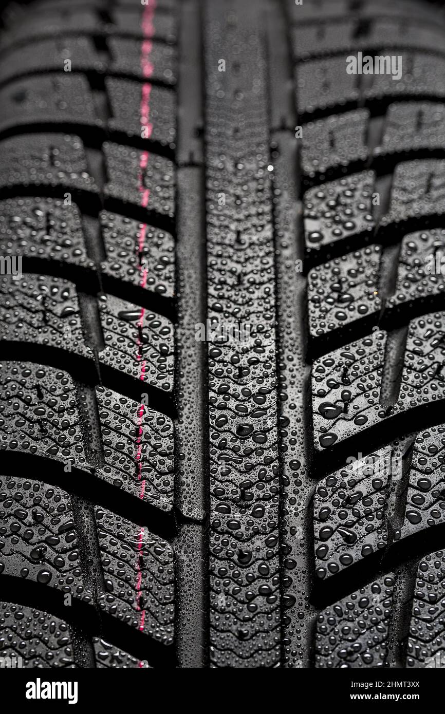 Car tires close-up Winter wheel profile structure with waterdrops on blue black background Stock ...
