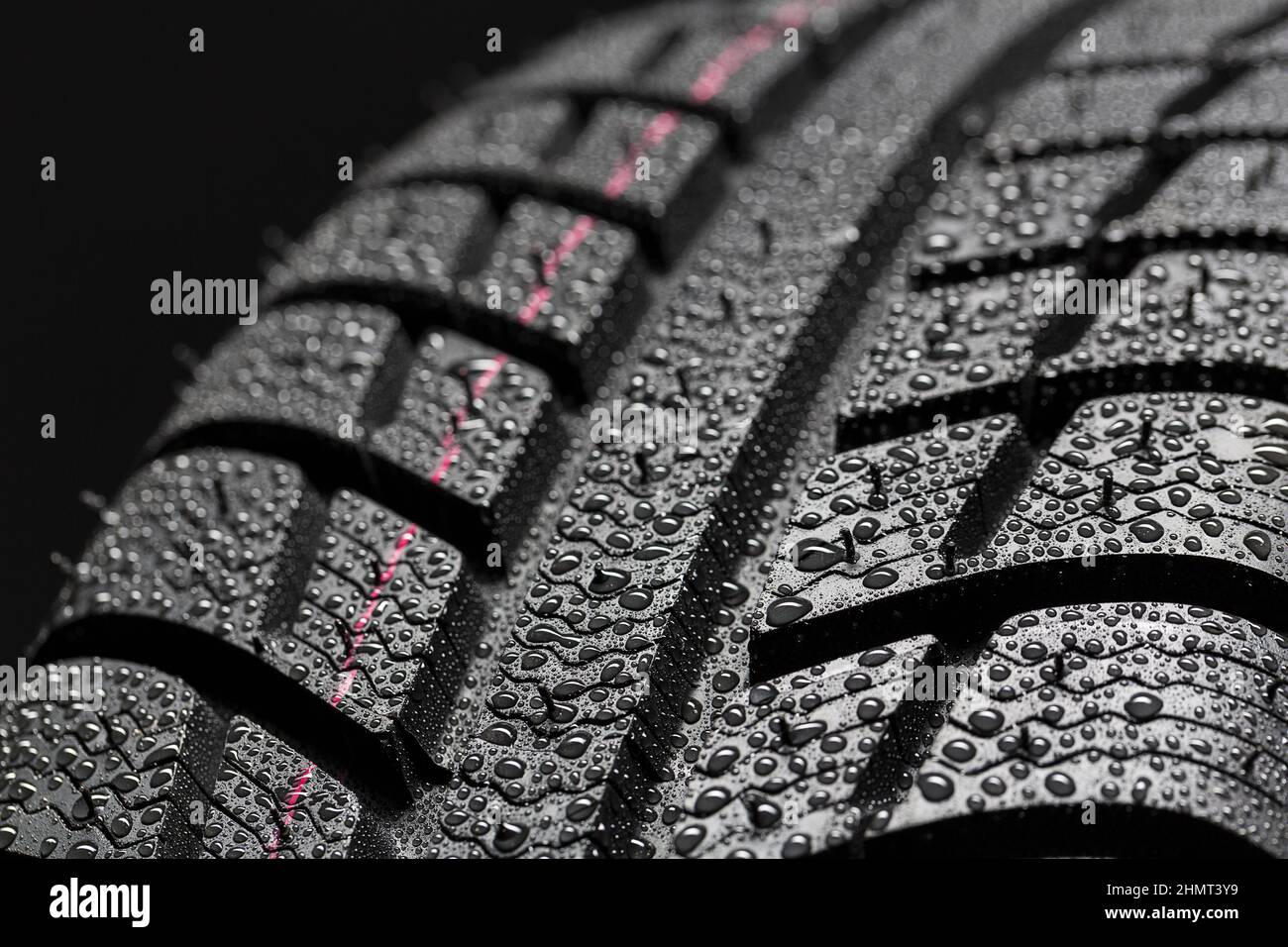 Car tires close-up Winter wheel profile structure with waterdrops on blue black background Stock ...