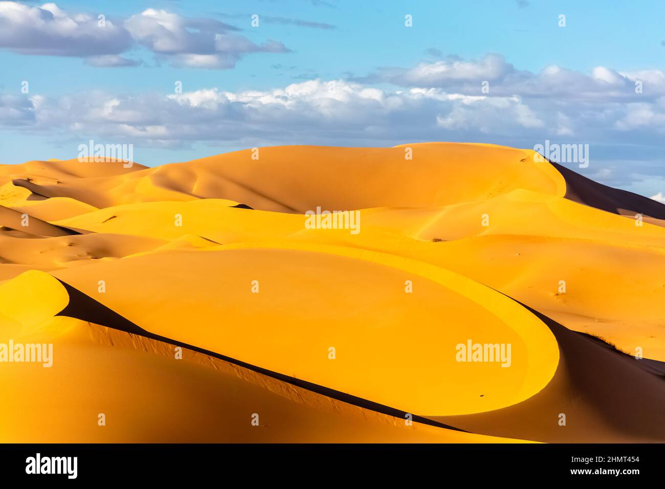 Contrasted shapes and shadows of golden yellow and orange colored sand ...