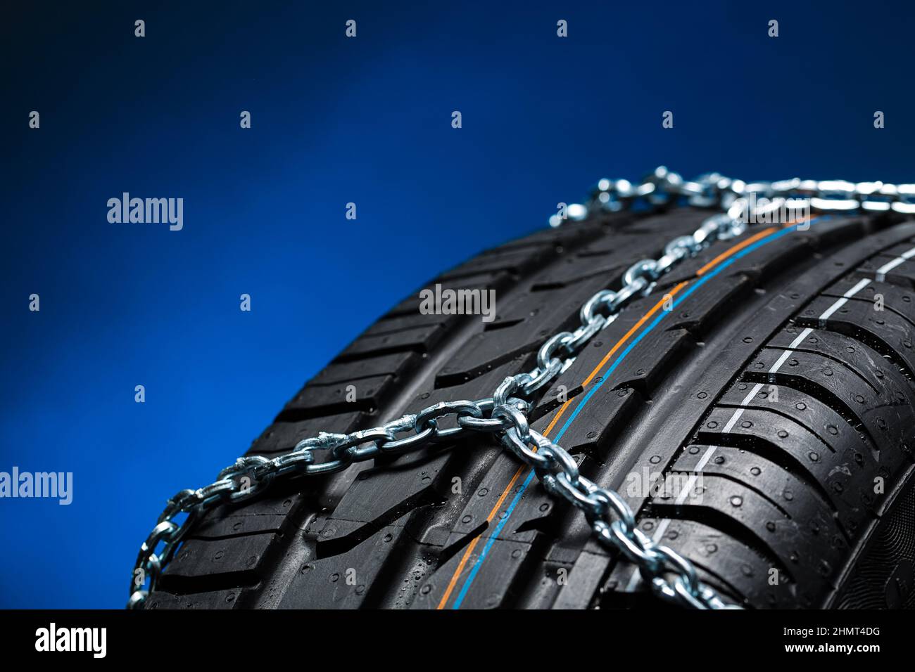 Car tyre with snow chain in the winter with blue background Stock Photo ...