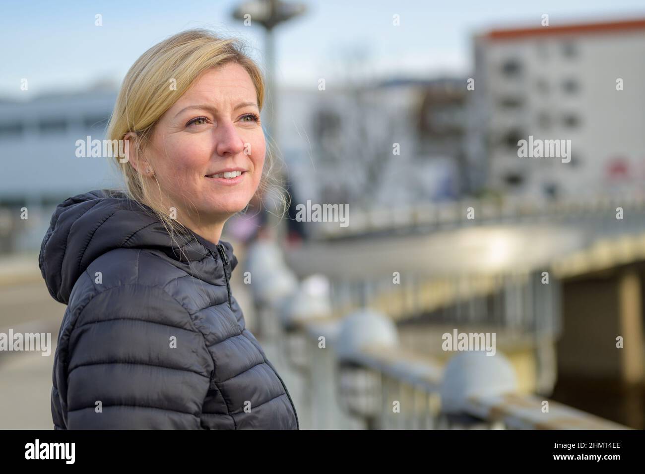 Cute young blond woman with an impish grin in an urban street Stock ...