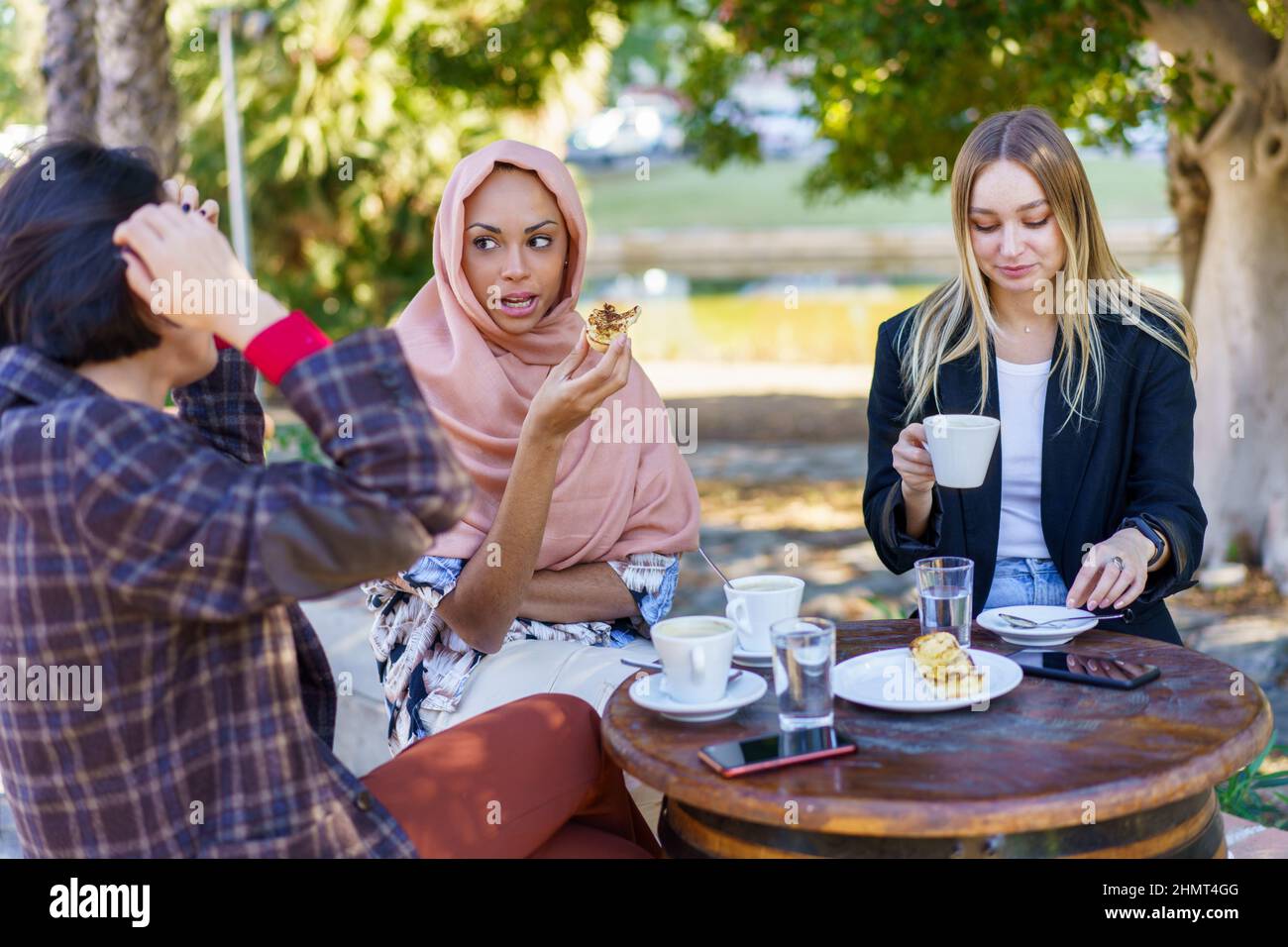 Multiracial women having coffee break on terrace of cafe Stock Photo ...