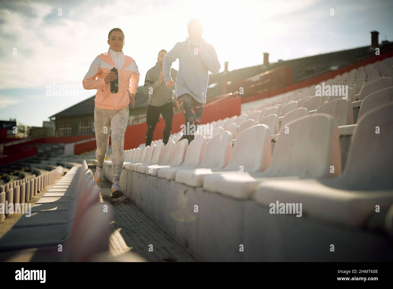 A group of young people is running on grandstand during a training on a ...