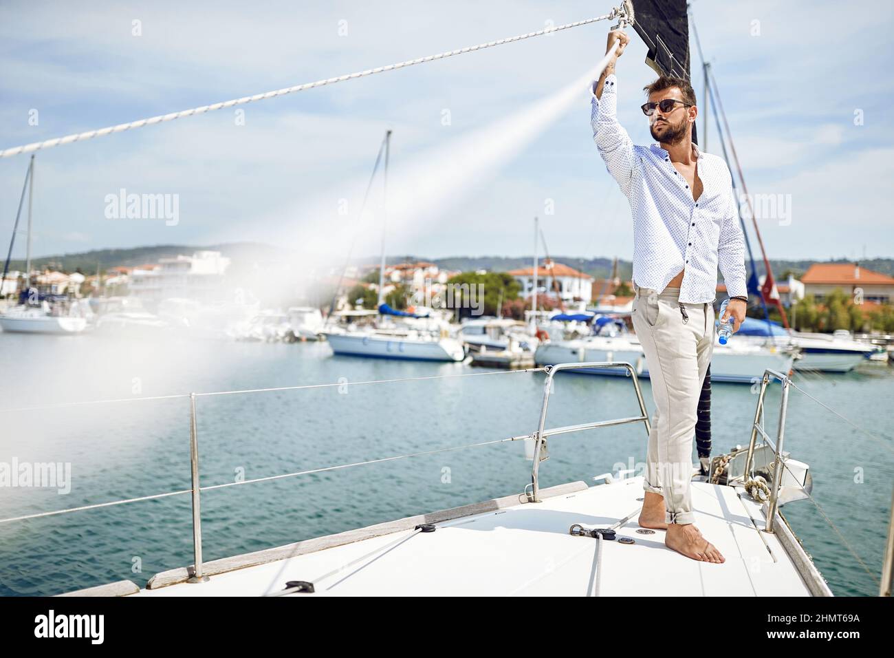Casual good-looking man sailing alone on the yacht Stock Photo - Alamy