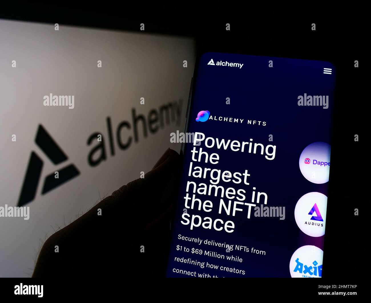 Person holding cellphone with webpage of US software company Alchemy ...