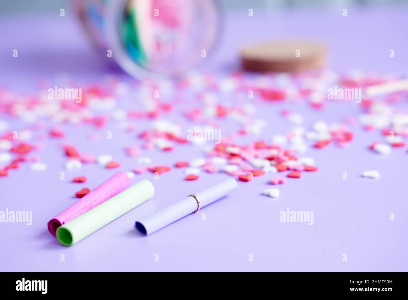 Small roll papers and a jar on a purple background. Jar with wishes for ...