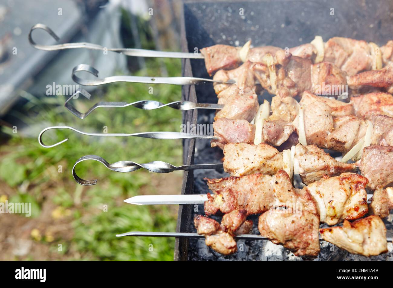Marinated shashlik preparing on a barbecue grill over charcoal ...