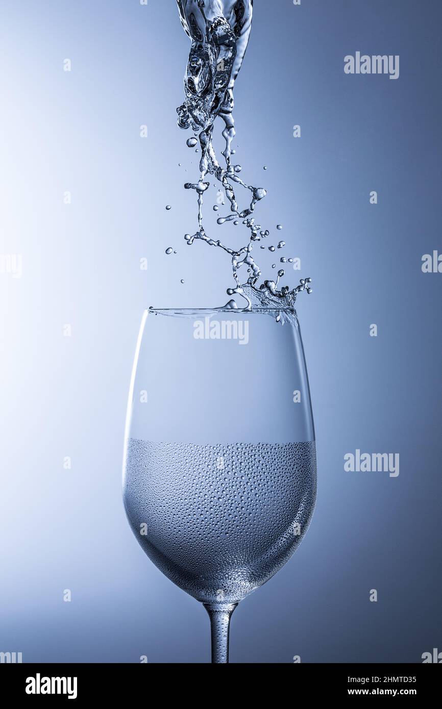Wine glass splash splatter rinse clean with condensation drops on blue ...