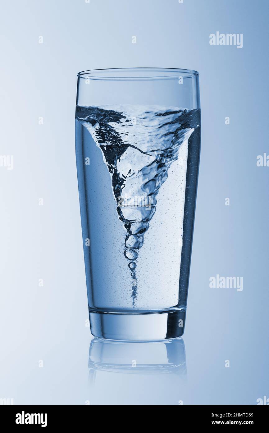 Storm tornado twister typhoon vortex in a water glass drinking on blue ...