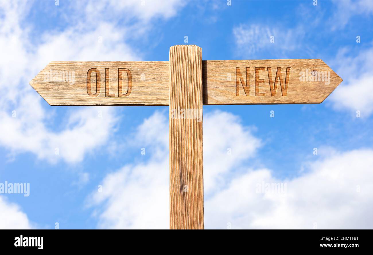 Old or New concept. Wooden signpost with message on sky background ...