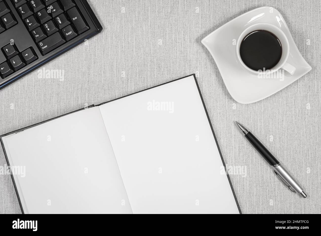 Open book on a workspace with sheets without writing Stock Photo - Alamy
