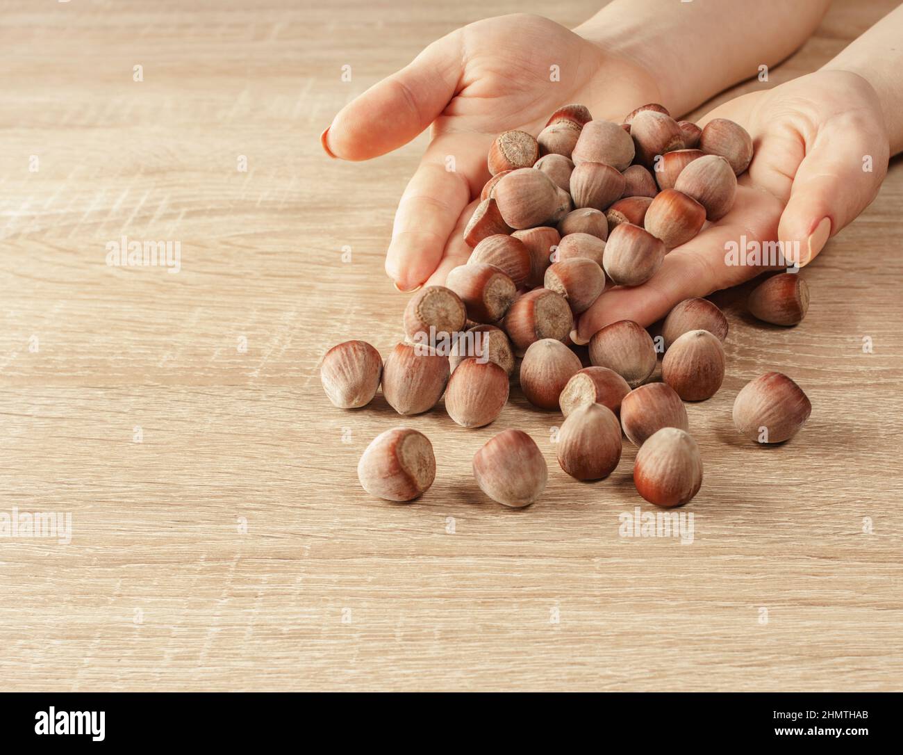 shelled hazelnuts in hands on a wooden background Stock Photo - Alamy