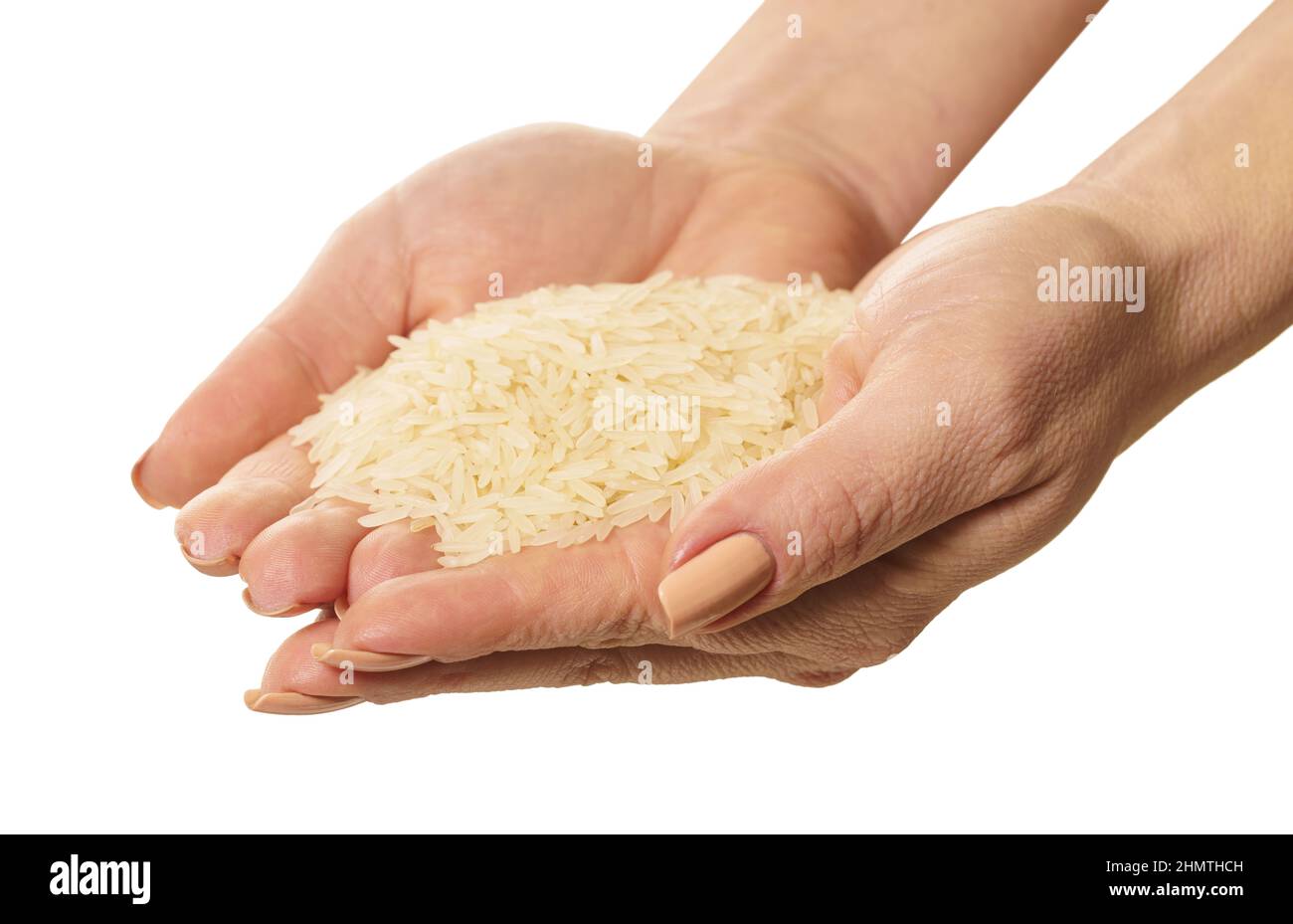 raw rice in hands on a white isolated background Stock Photo - Alamy