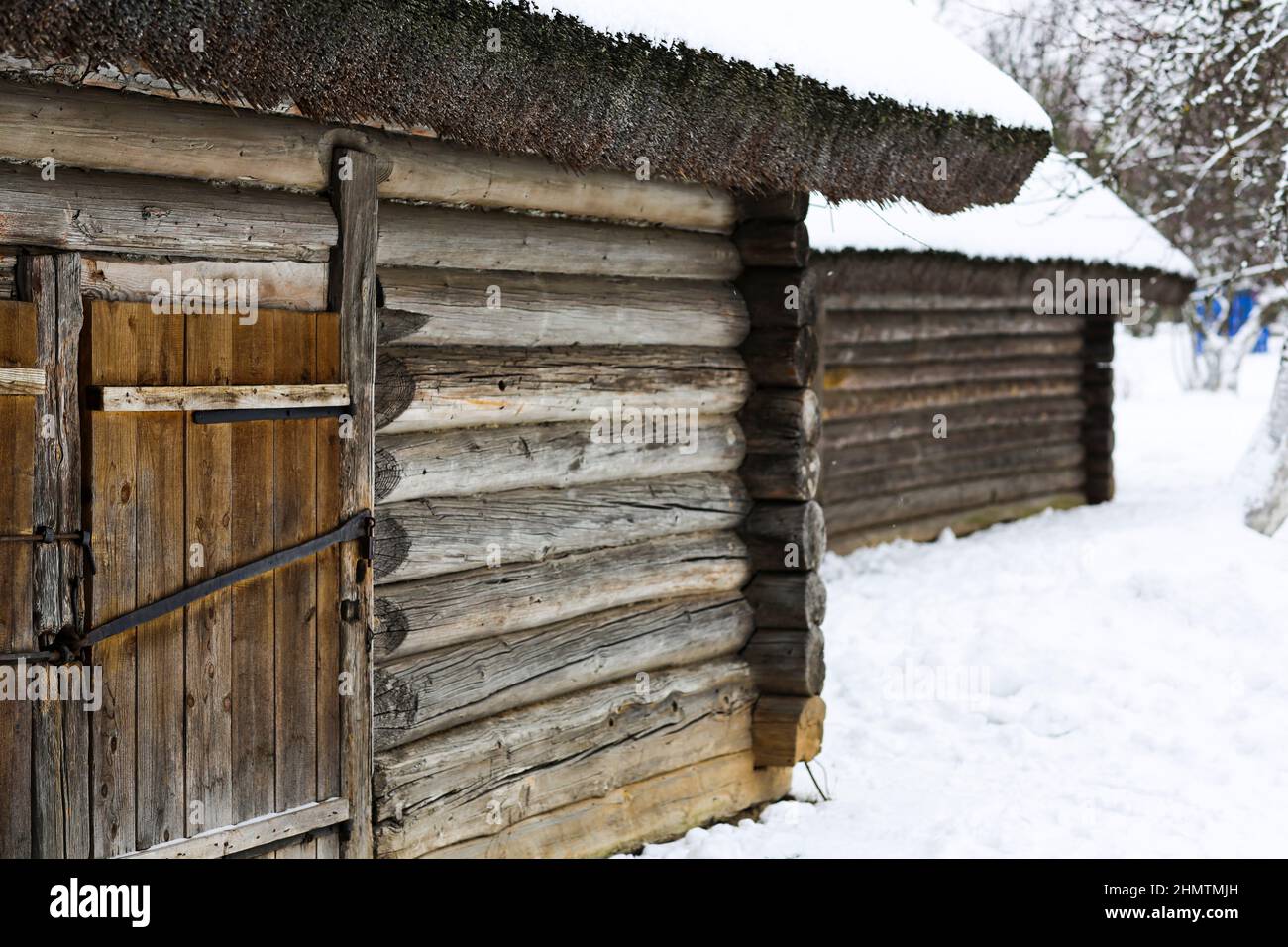 Winter Russian landscape. An old wooden hut, a log house with a ...