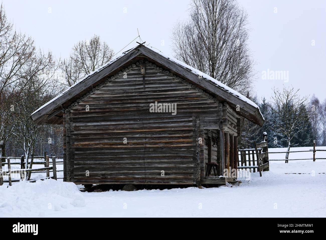 Winter Russian landscape. An old wooden hut, a log house with a ...
