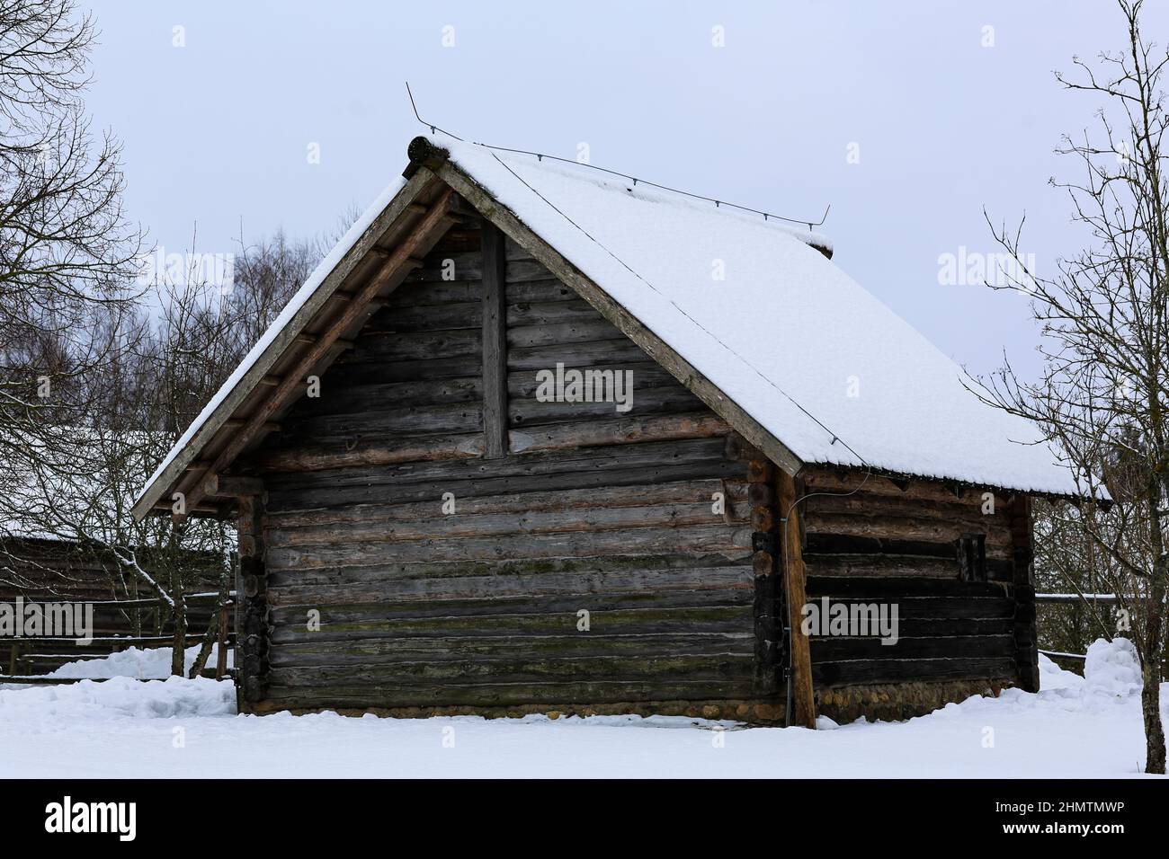 Winter Russian landscape. An old wooden hut, a log house with a ...