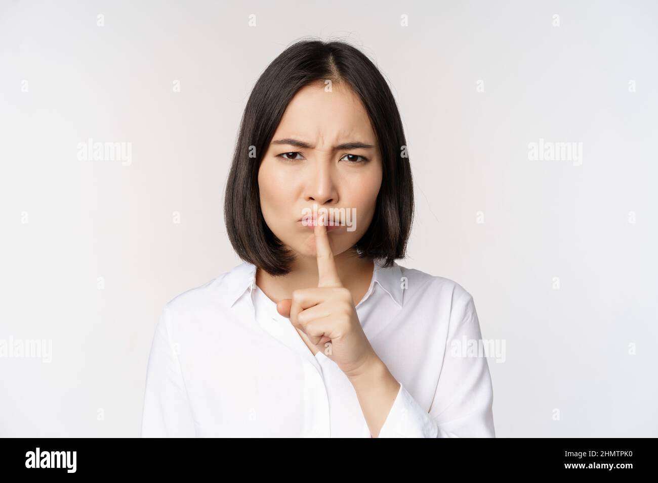 Close up portrait of young asian woman making hush, shhh shush sign ...