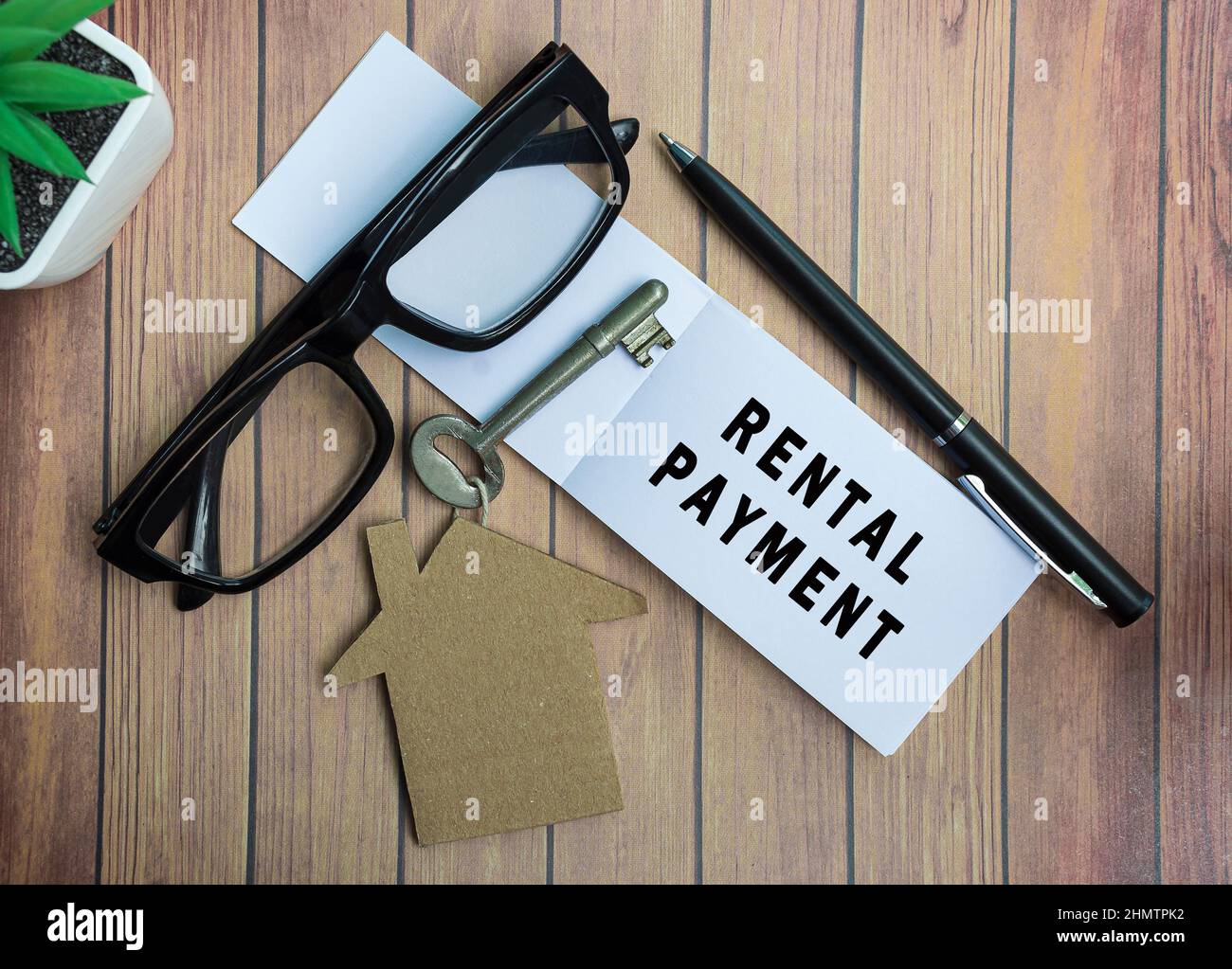 Rental payment text on notepad with house model and key on wooden desk ...