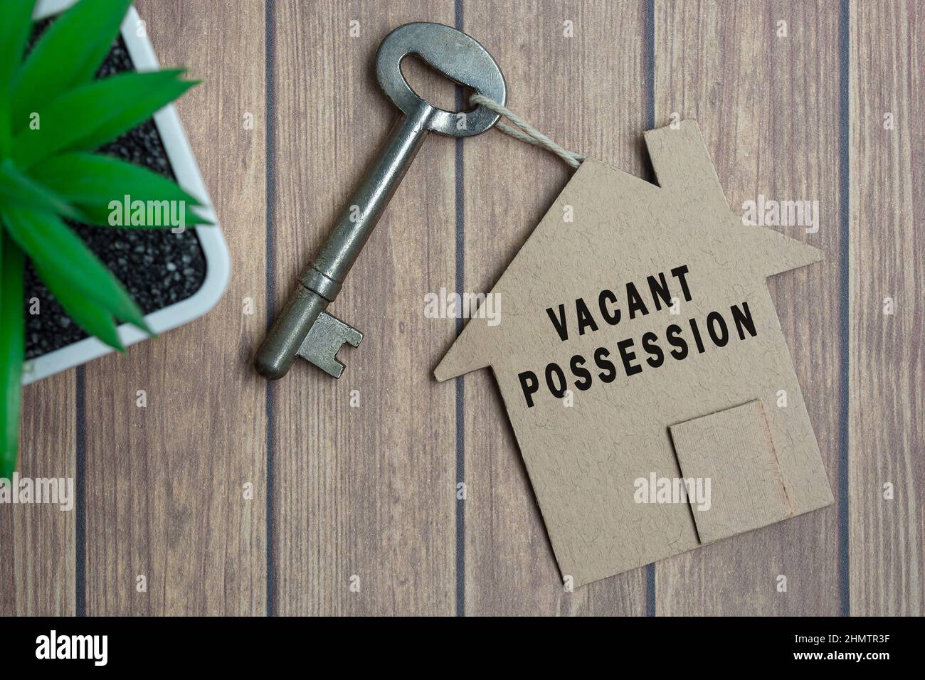 Vacant possession text on house model and key on wooden desk. Directly ...