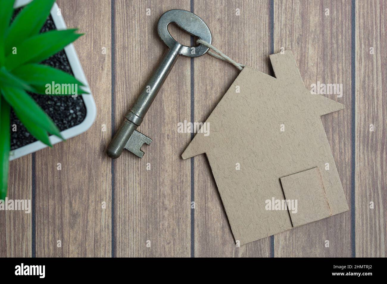 House model and key on wooden desk. Directly above. Flat lay for text ...
