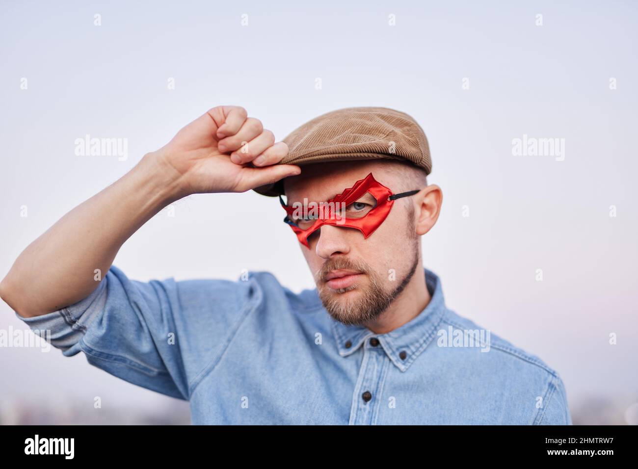 Cute man in red superhero mask and jeans shirt posing in front of the ...