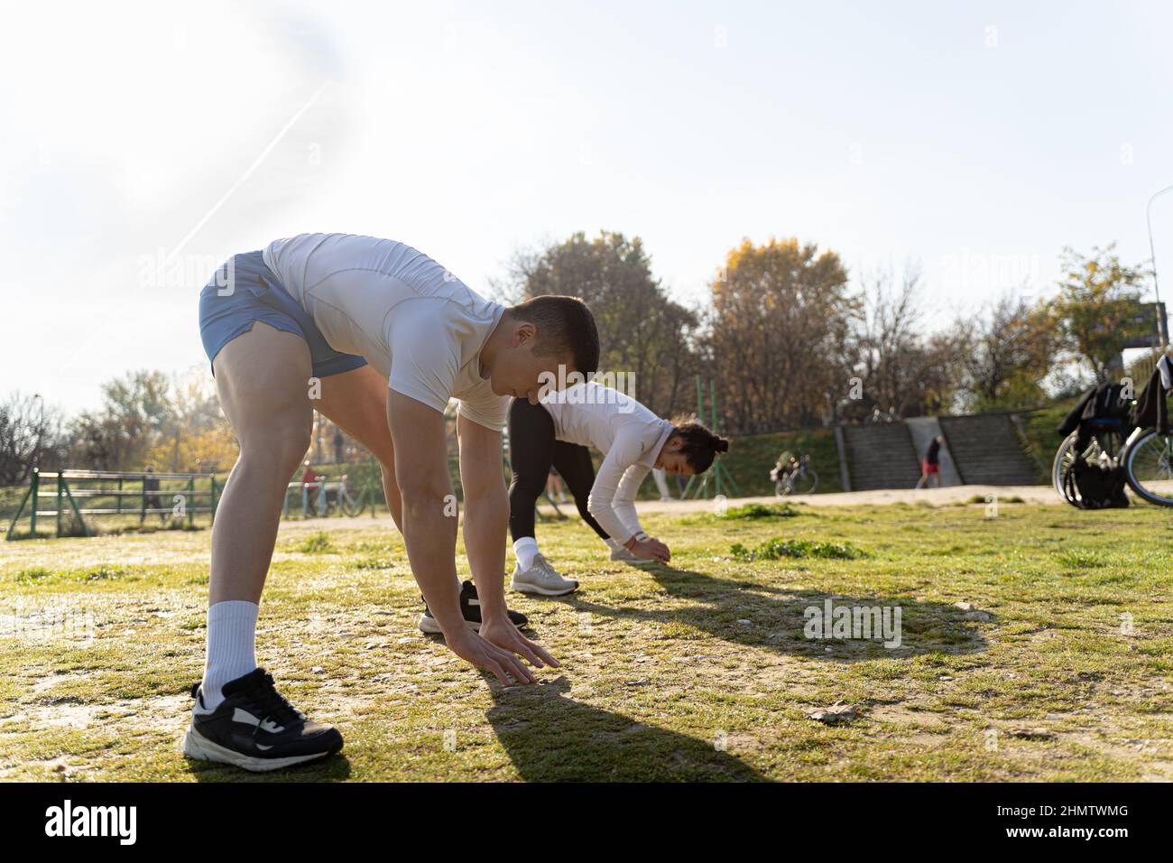 Two amazing and attractive friends are stretching on the grass Stock ...