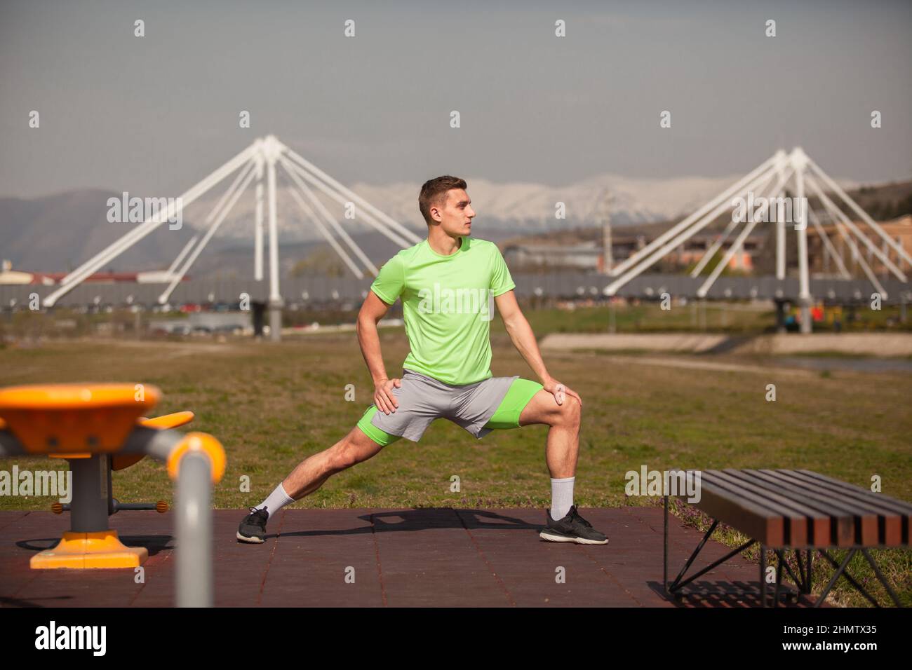 Handsome and active guy is stretching before his training outside Stock ...