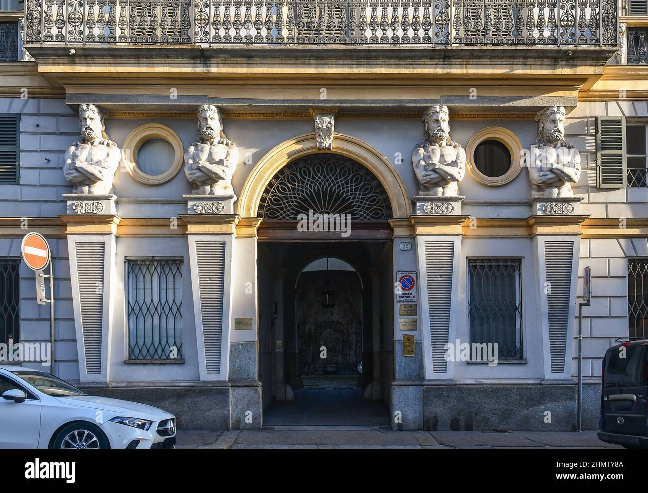 Façade of an old palace with telamons of Hercules with the skin of the ...