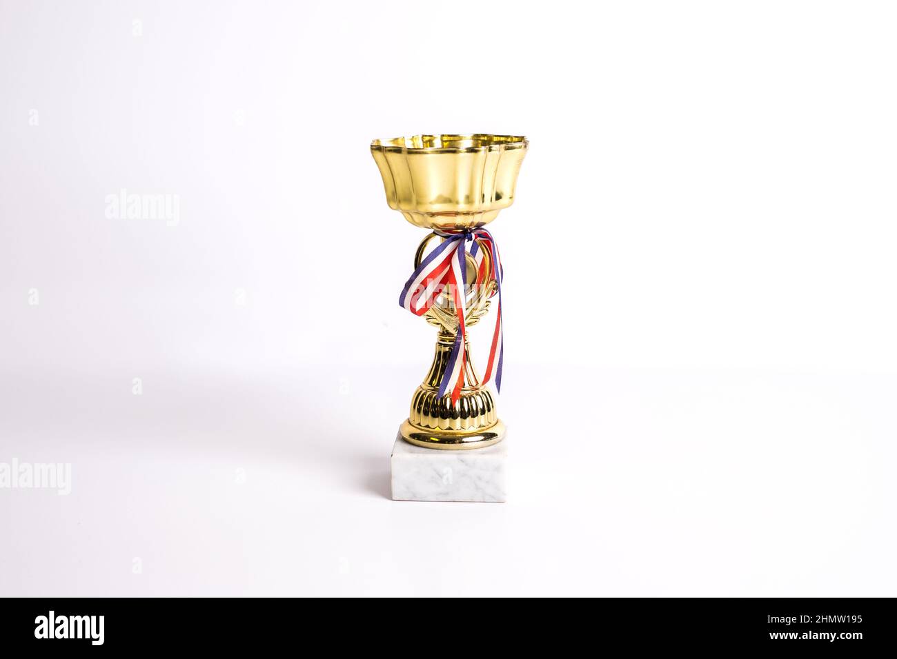 Isolated gold cup trophy award with ribbon on blank background goblet ...