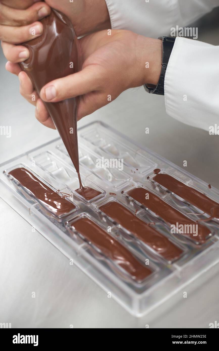 production, food preparation and people concept - confectioner with ...