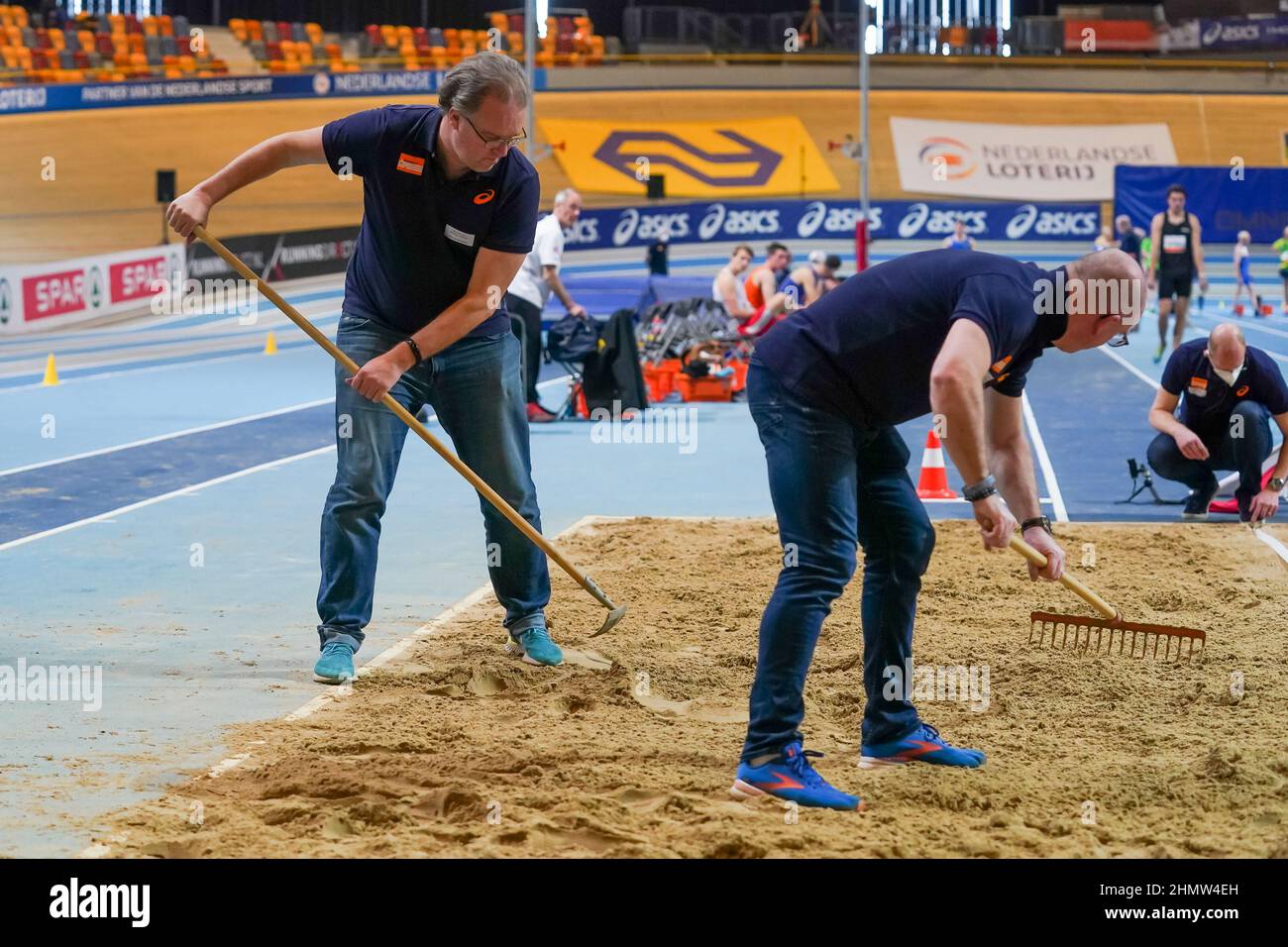 Volunteers prepare the long jump landing pit hi-res stock photography ...