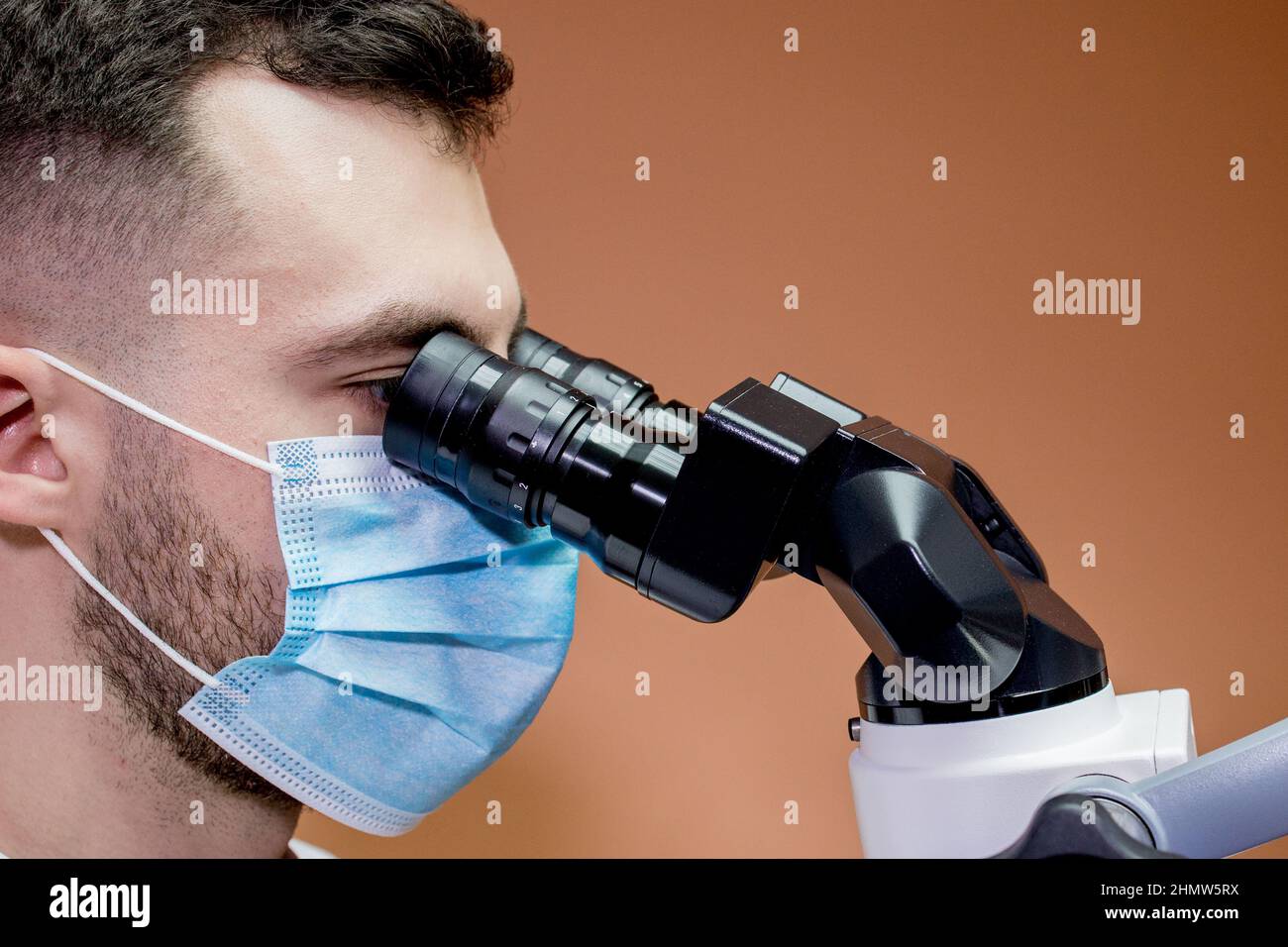 A young scientist conducting research with a microscope. Working with a ...