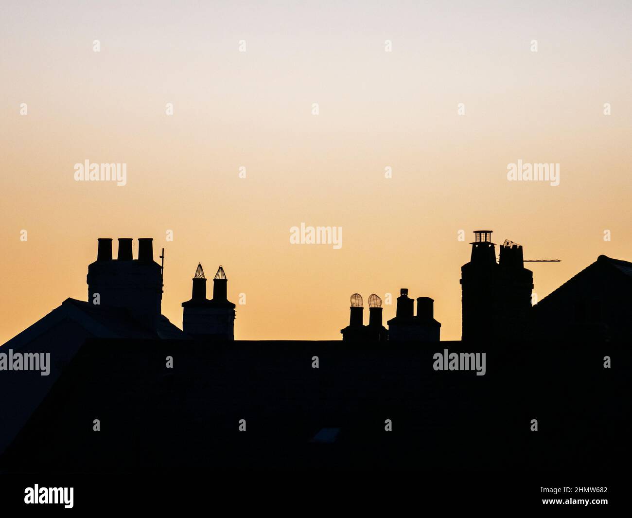 House rooves and chimney pots silhouetted at dawn, Beadnell ...