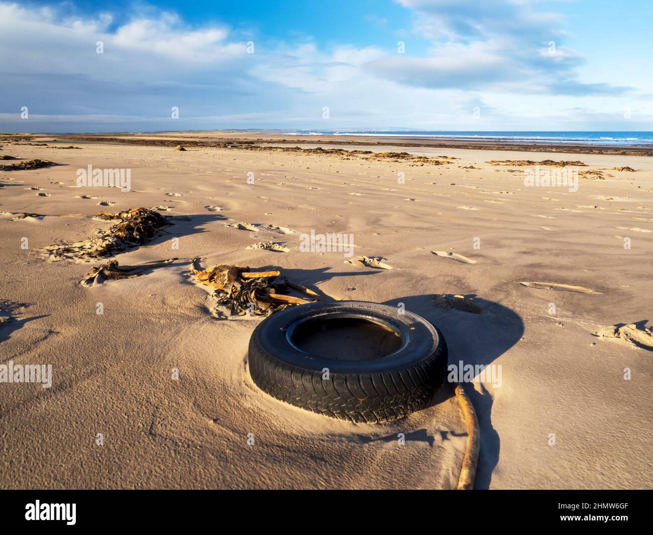 A car tyre washed up on the beach on Holy Island, Northumberland, UK ...